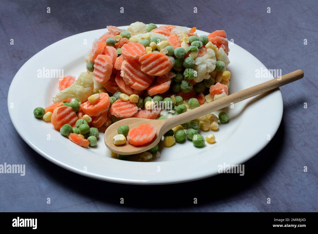 Frozen vegetables on plate with cooking spoon, frozen food Stock Photo ...