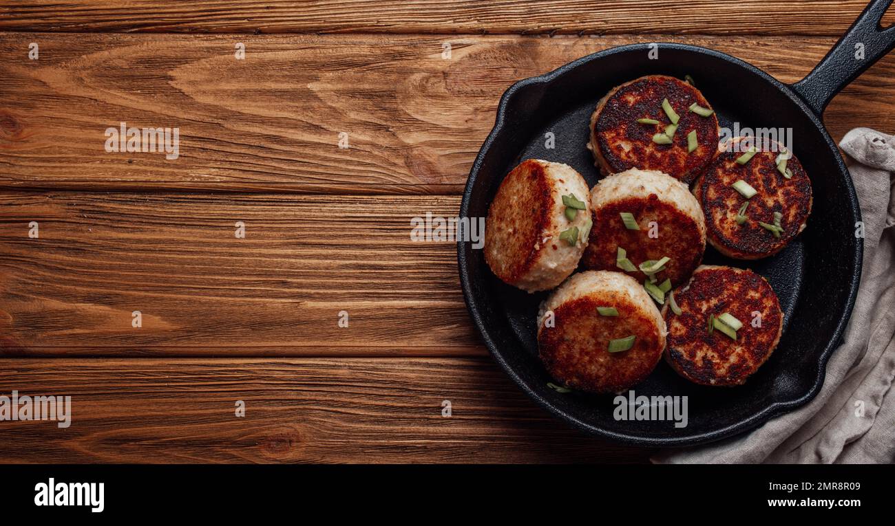 Homemade cutlets from fish, chicken or meat on black cast iron frying ...