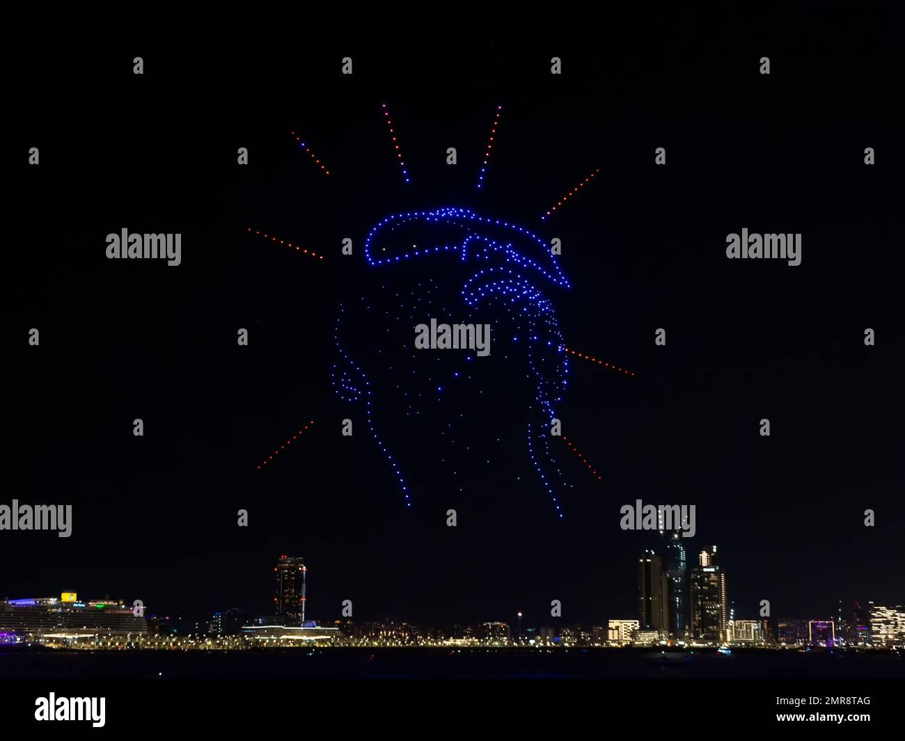 The illuminated blue drones glowing in the black night sky and forming ...