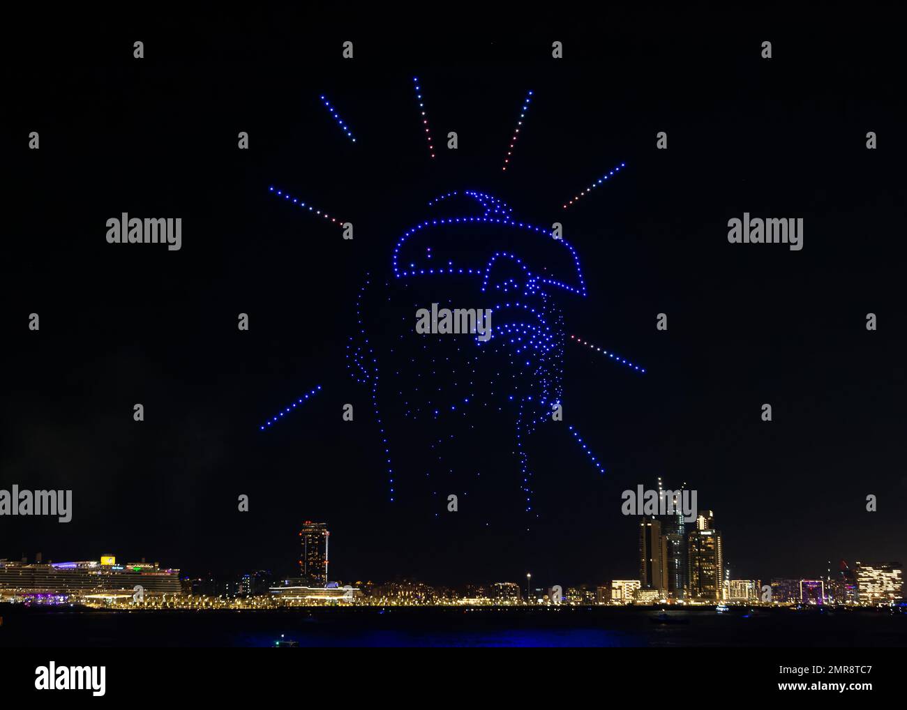 The illuminated blue drones glowing in the black night sky and forming ...