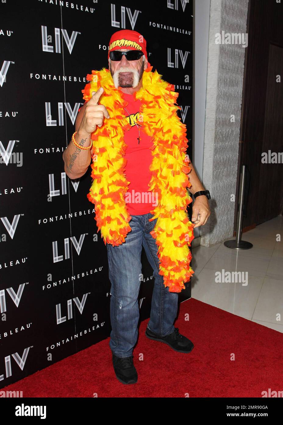 Hulk Hogan wears a bright yellow & orange feathered boa as he arrives ...