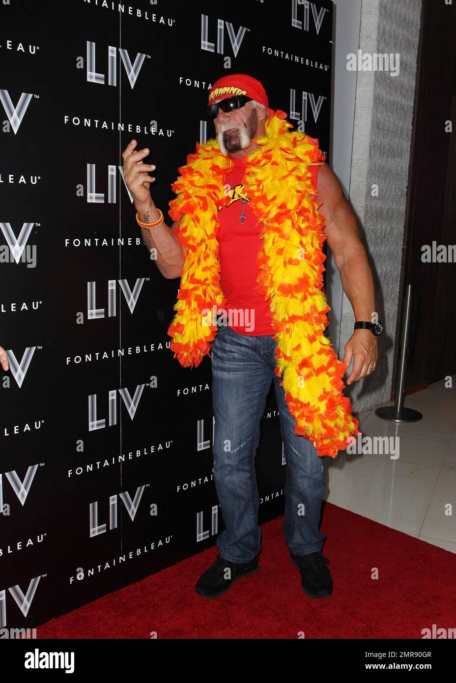 Hulk Hogan wears a bright yellow & orange feathered boa as he arrives ...