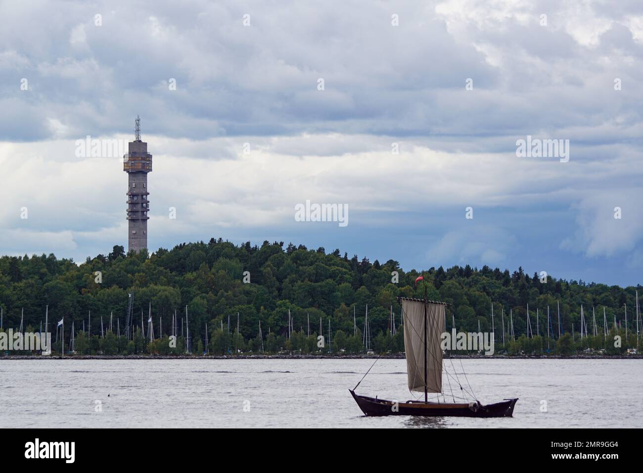 Small old wooden boat in sea in front of landmark Stock Photo - Alamy