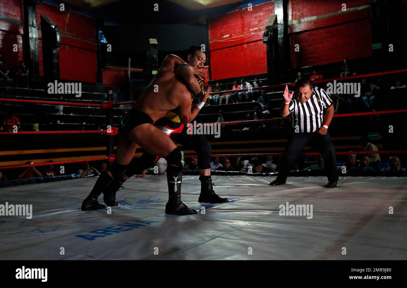 In this Sept. 17, 2017 photo, wrestler Super puts rival Imposible in a ...