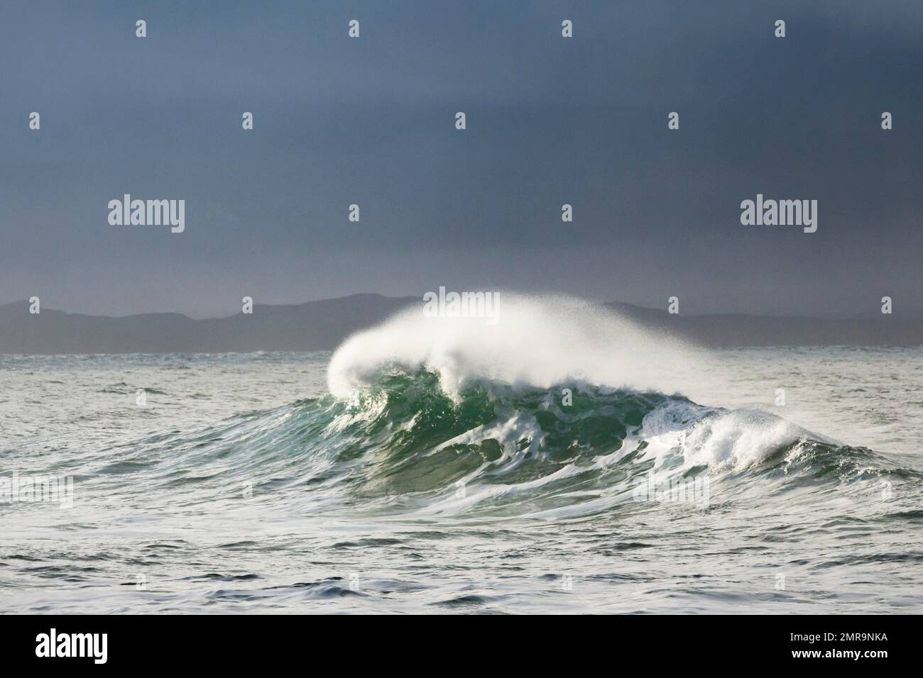 Big wave breaks in winter storm in open sea and dramatic light off ...