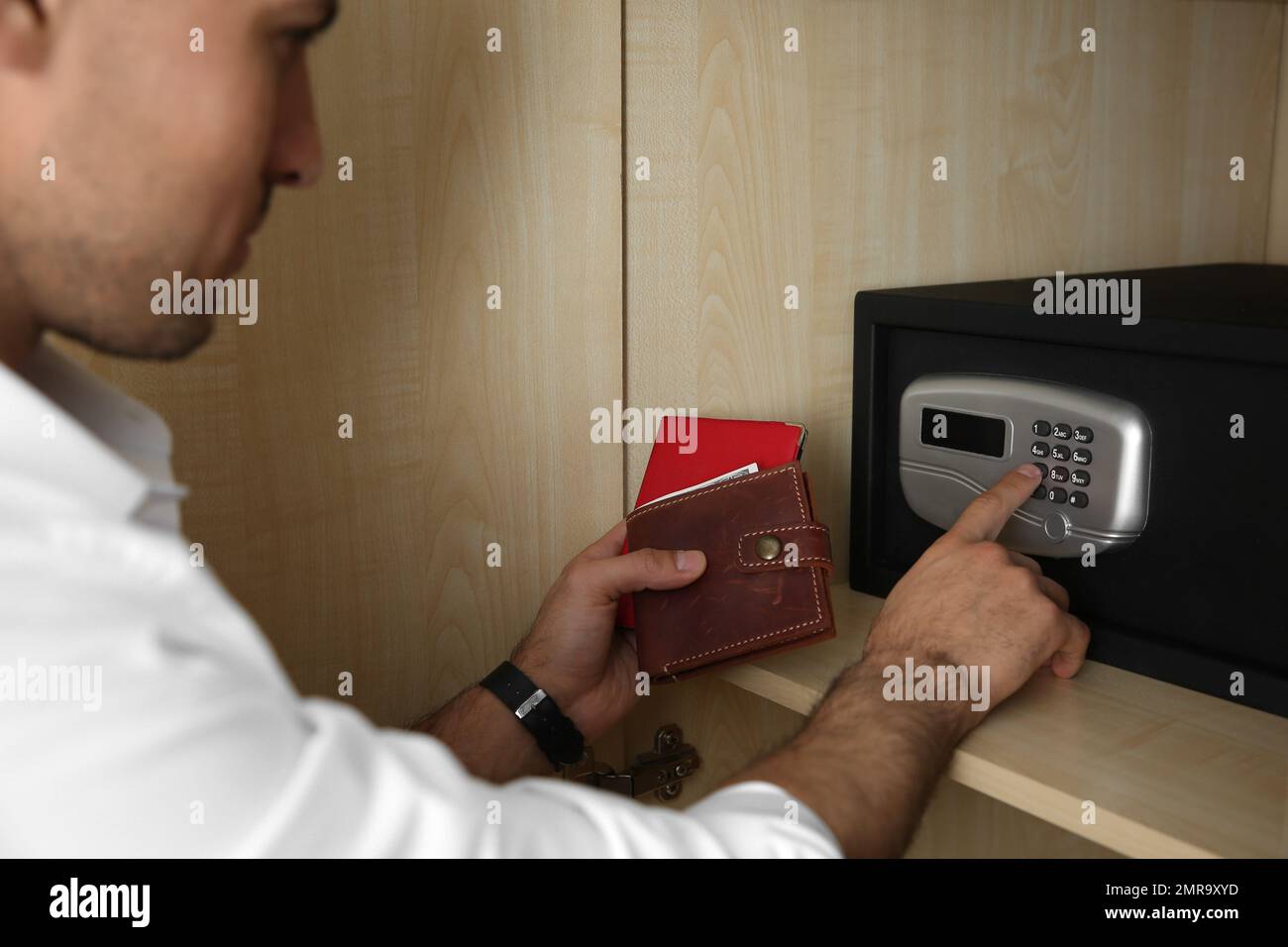 Man opening black steel safe with electronic lock at hotel, closeup ...