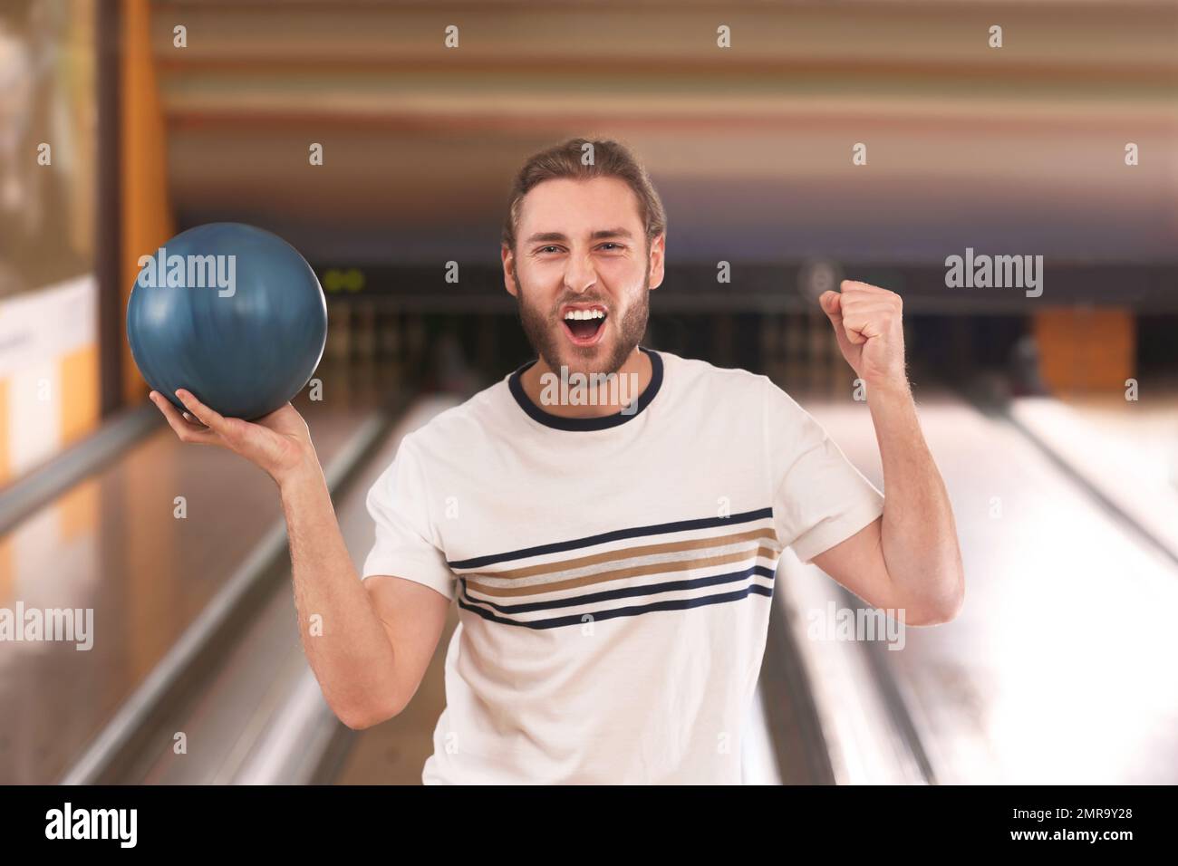 Young man with ball in bowling club Stock Photo - Alamy