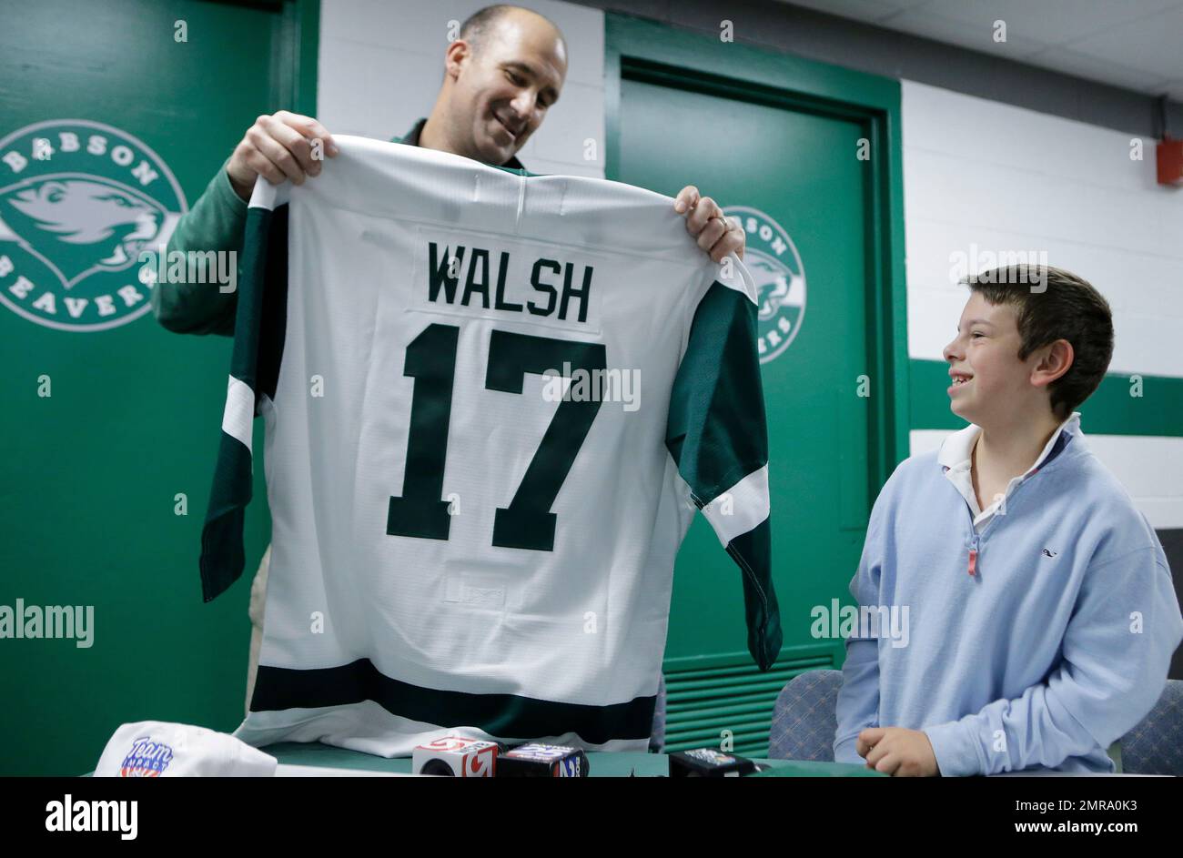 Coleman Walsh, 10, of Walpole, Mass., right, is presented with a team ...