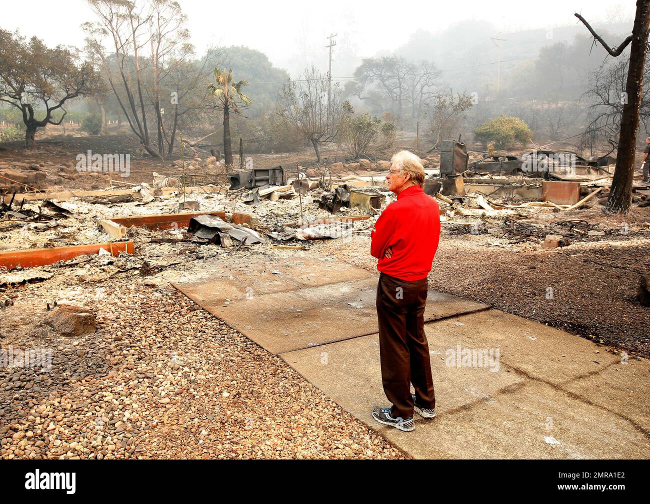 Mike Rippey looks over the burned out remains of his parents home at ...