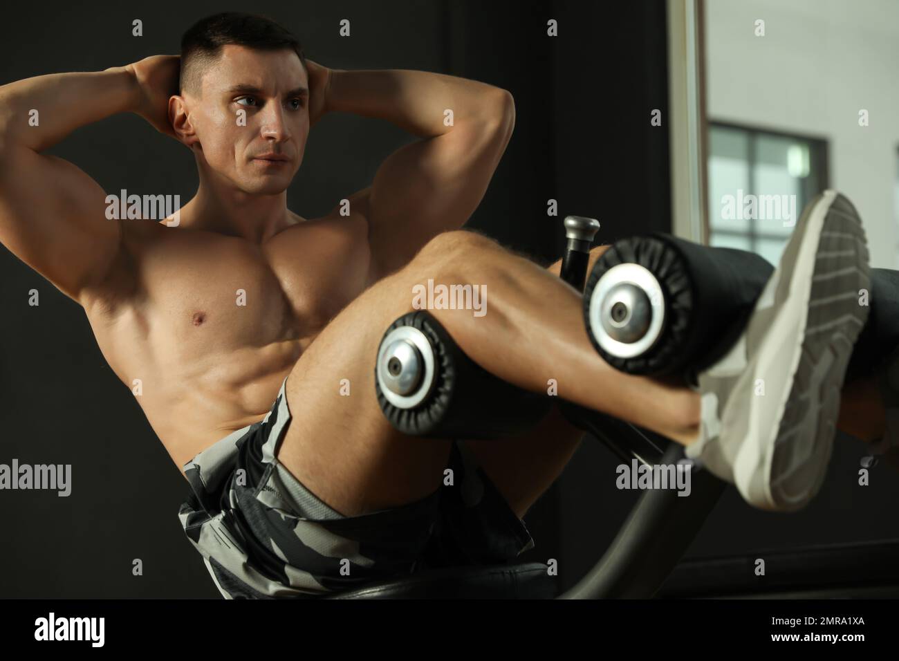 Man working out on adjustable sit up bench in modern gym Stock Photo ...