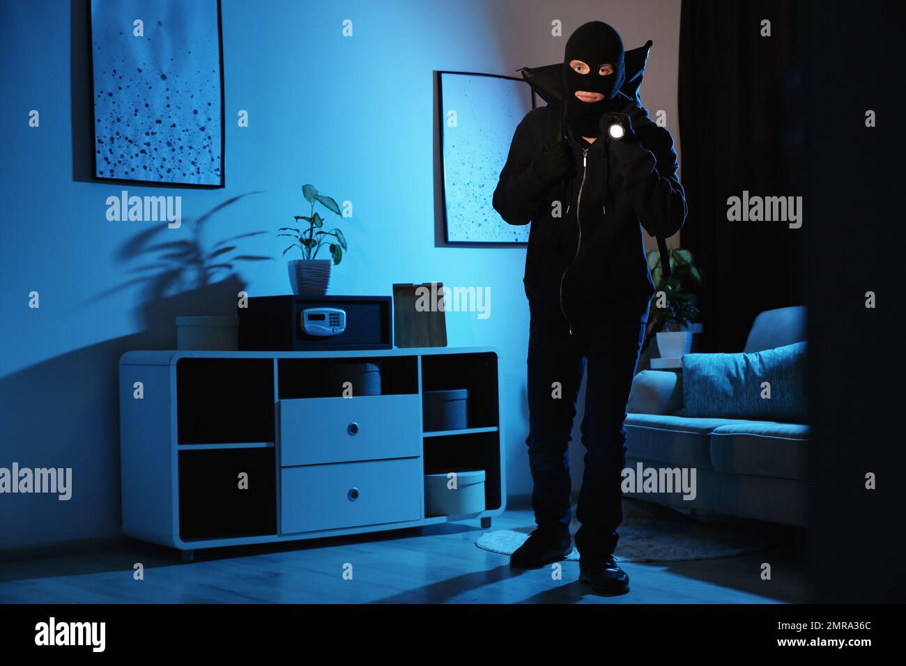 Thief with flashlight near steel safe indoors at night Stock Photo - Alamy