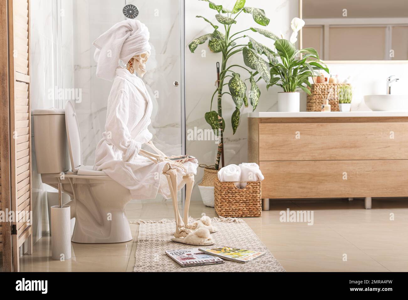 Skeleton in bathrobe with mobile phone sitting on toilet bowl Stock ...