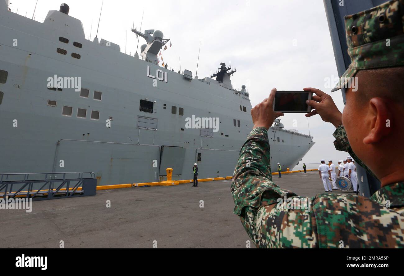 A Philippine Navy personnel takes a photo of the Royal Australian Navy ...