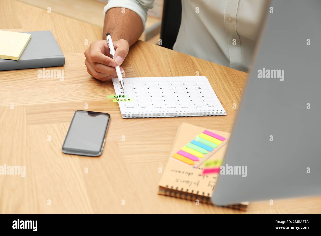 Man making schedule using calendar at table in office, closeup Stock ...