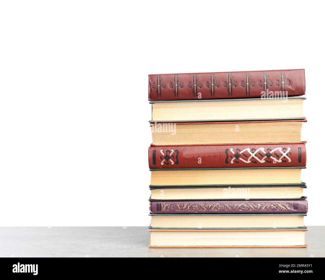 Stack of old vintage books on stone table against white background ...