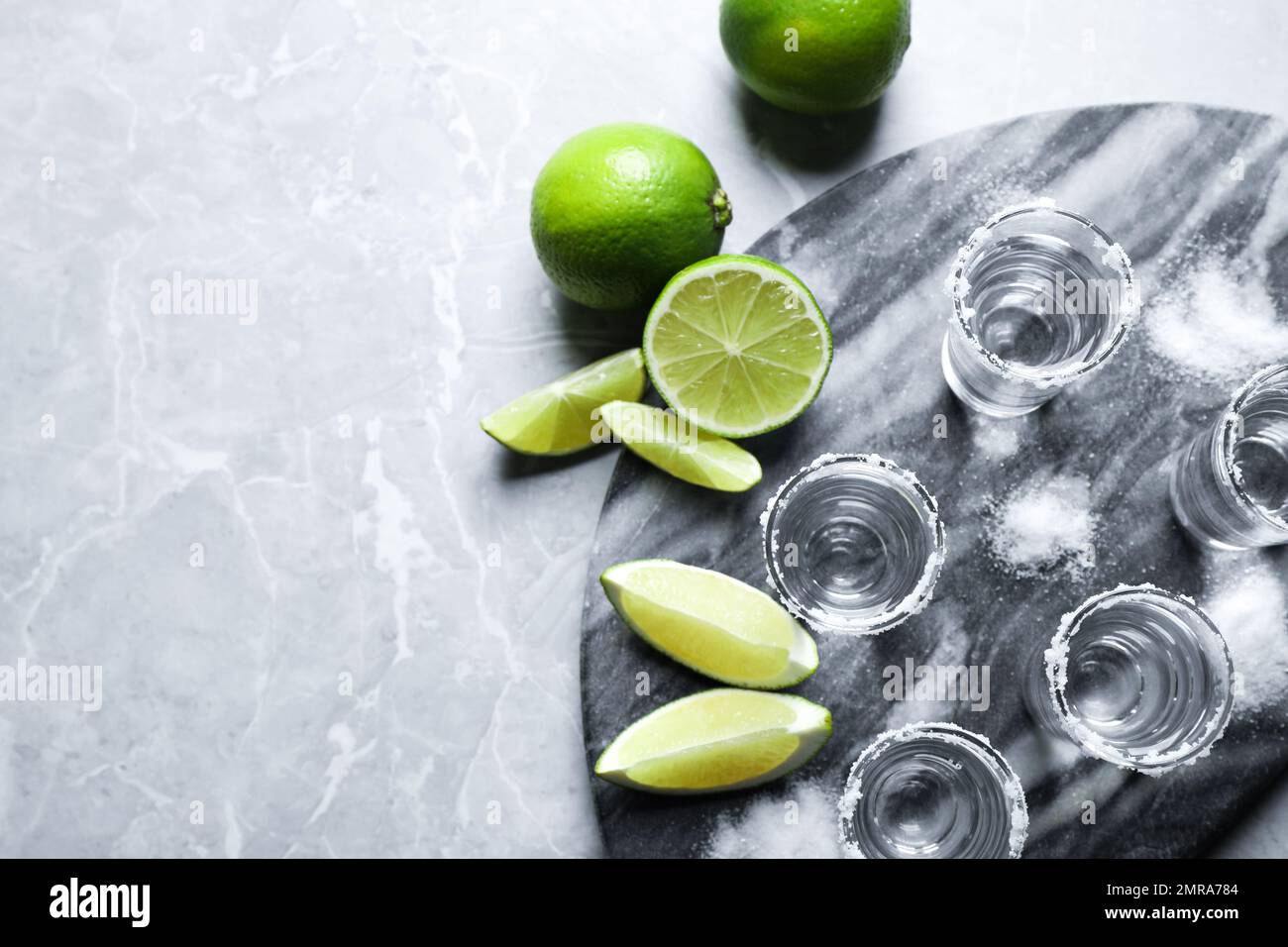 Mexican Tequila shots, lime slices and salt on grey marble table, flat ...