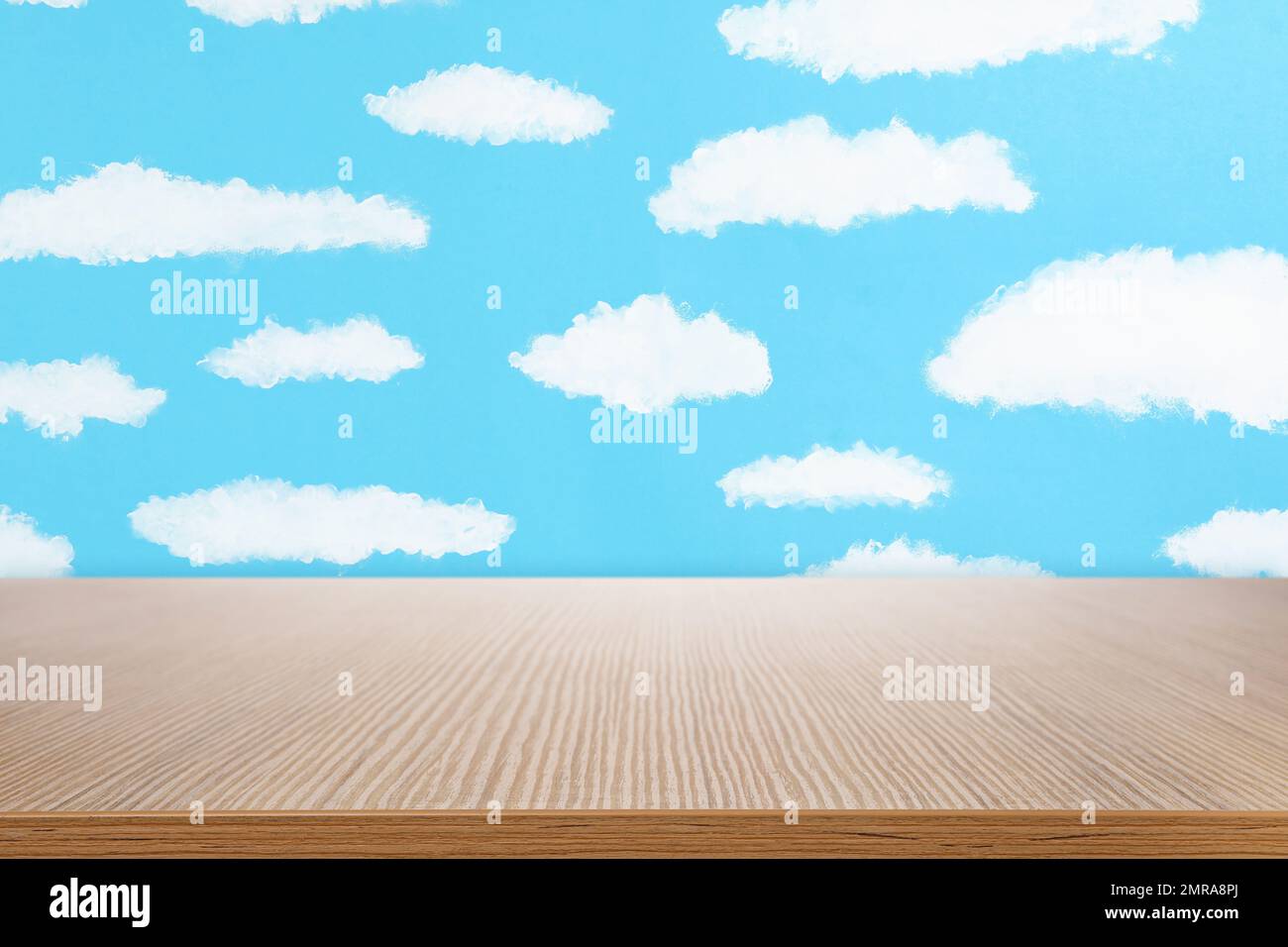 Wooden table near wall with painted clouds. Idea for baby room interior ...