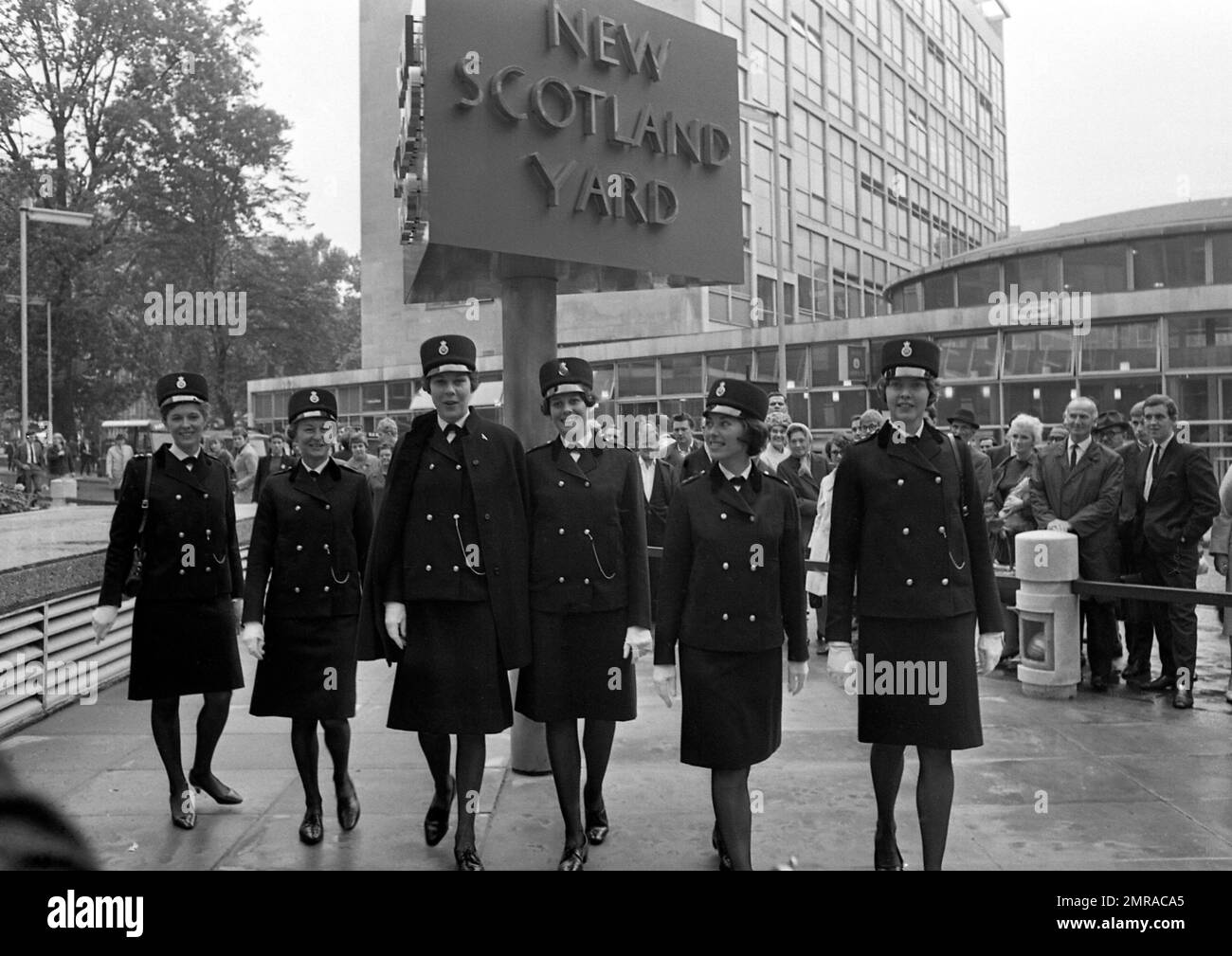 Standing in the foreground of New Scotland Yard, London, are six London ...