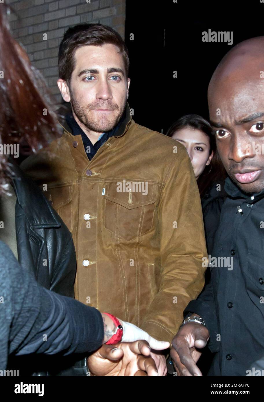 Guided by bodyguards, actor Jake Gyllenhaal arrives at the Apple Store ...
