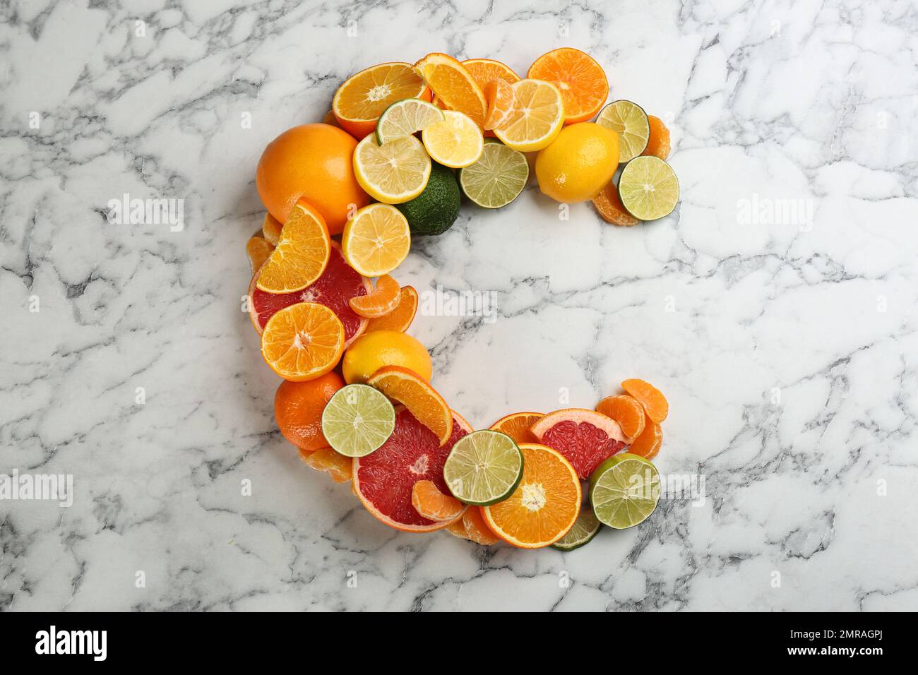 Letter C made with citrus fruits on marble table as vitamin ...