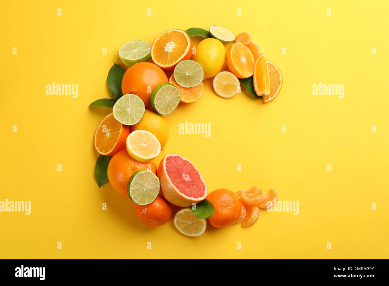 Letter C made with citrus fruits on yellow background as vitamin ...