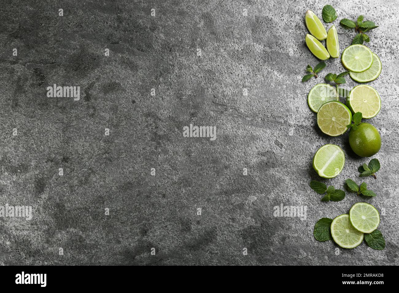 Lemonade layout with juicy lime slices and mint on grey table, top view ...