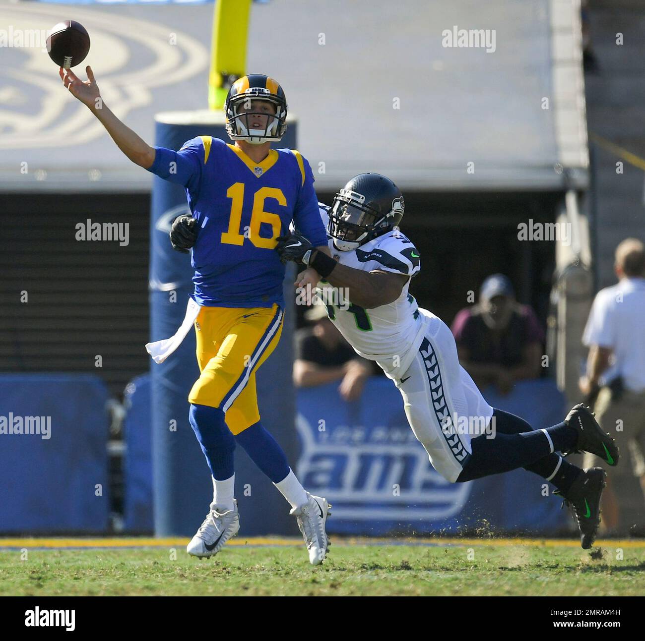Los Angeles Rams quarterback Jared Goff, left, passes under pressure by ...