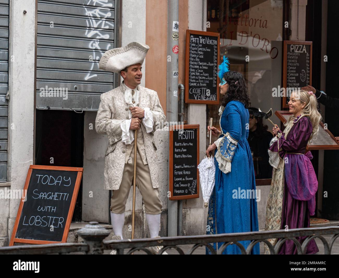 People in medieval carnival costumes - a man talks with two women in ...
