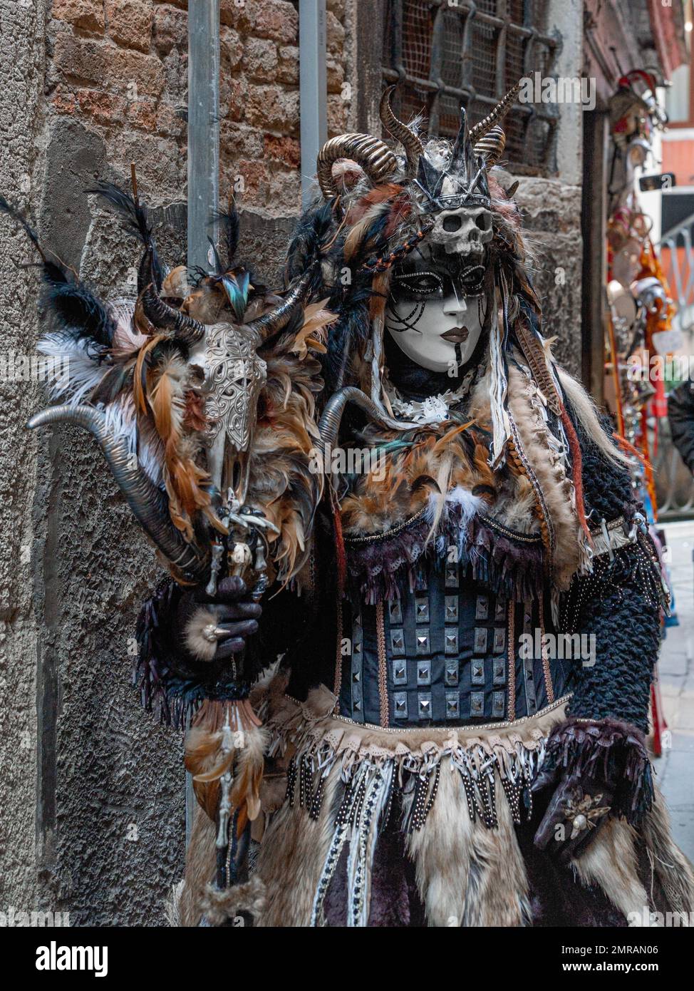 A model dressed in carnival costume of pagan witch with the sculls ...