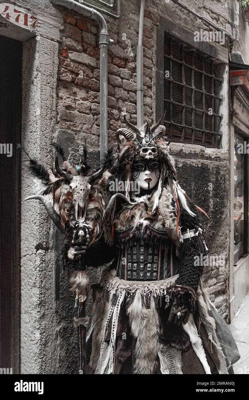 A model dressed in carnival costume of pagan witch with the sculls ...