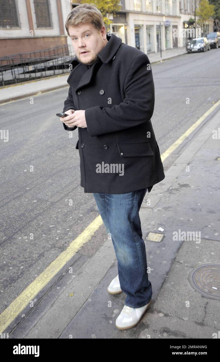 British writer and TV personality James Corden texts on his cell phone ...