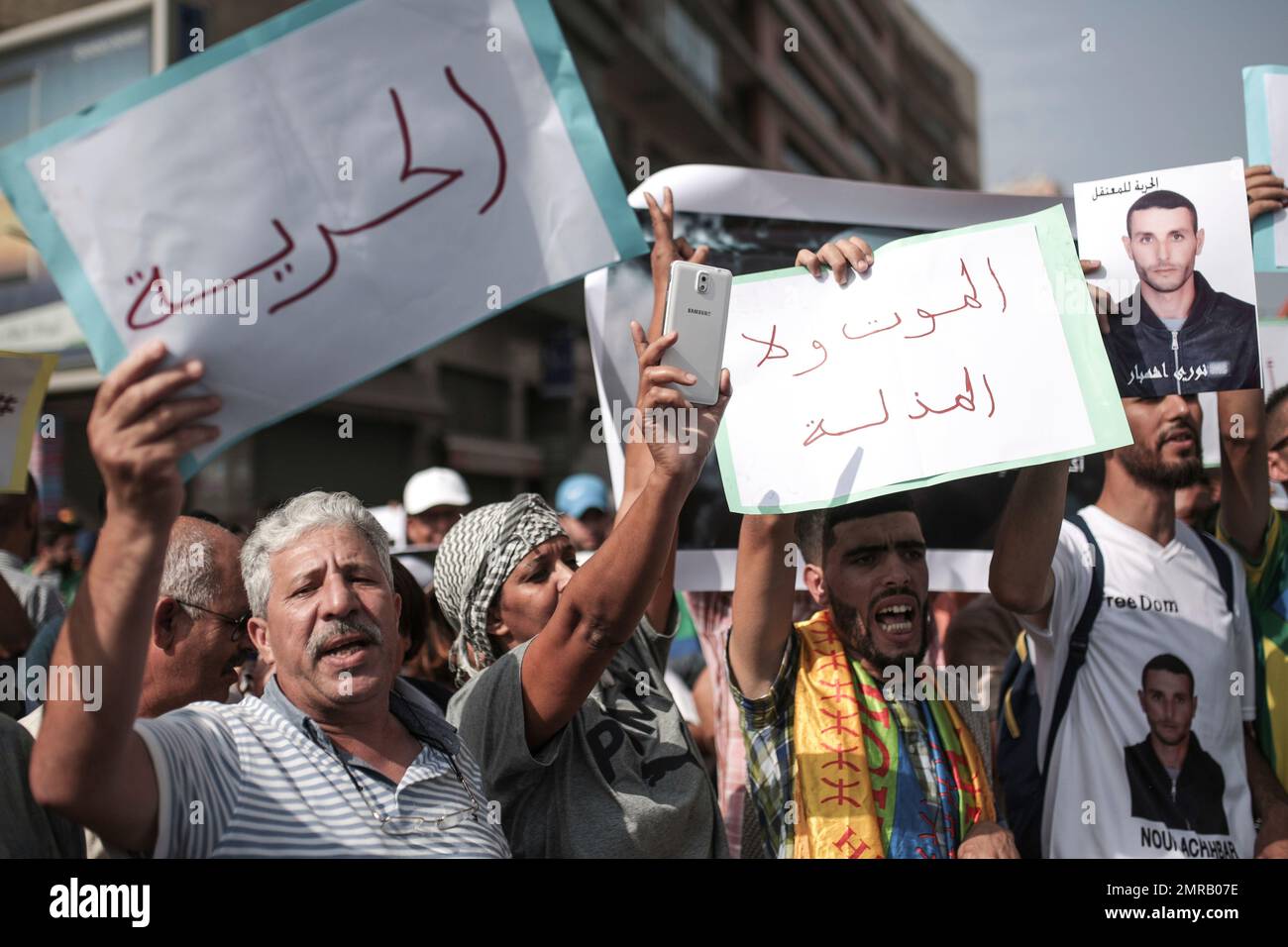 Demonstrators hold banners in Arabic reading "freedom" and "Death over ...