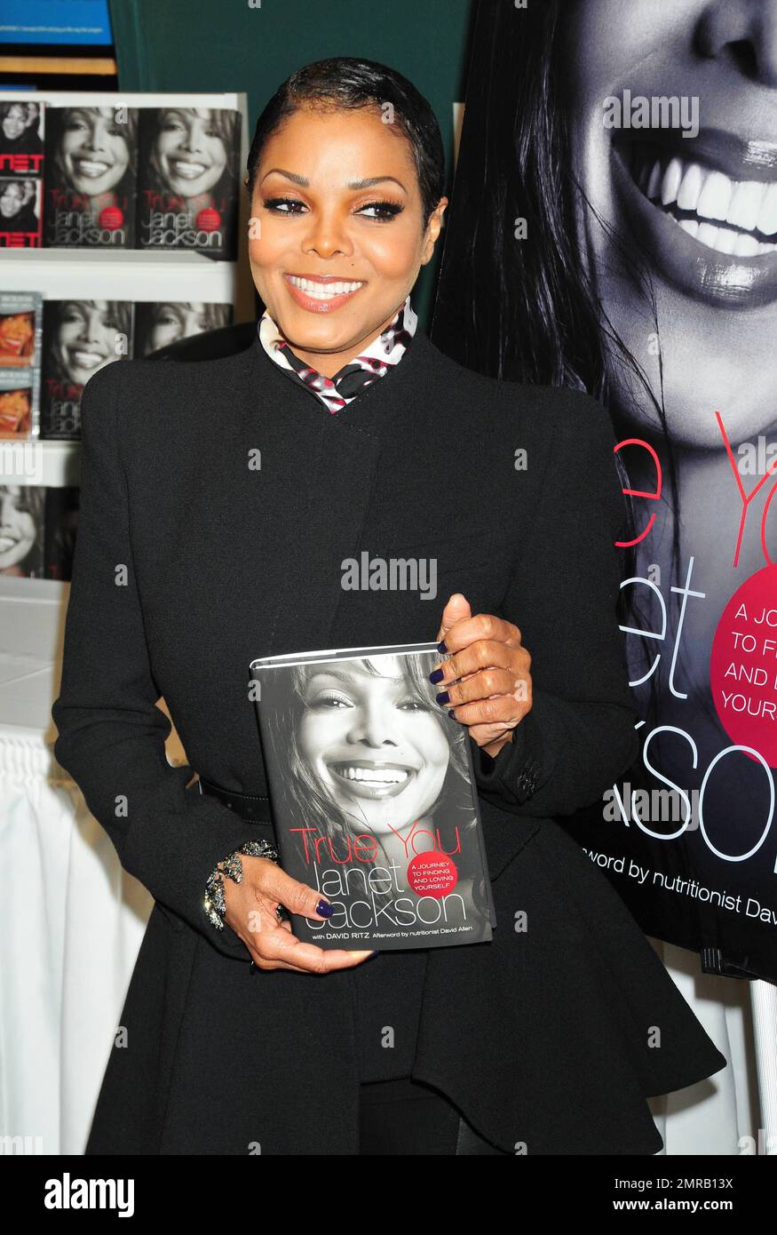 Singer Janet Jackson shows off her short slicked back hair and wears a ...