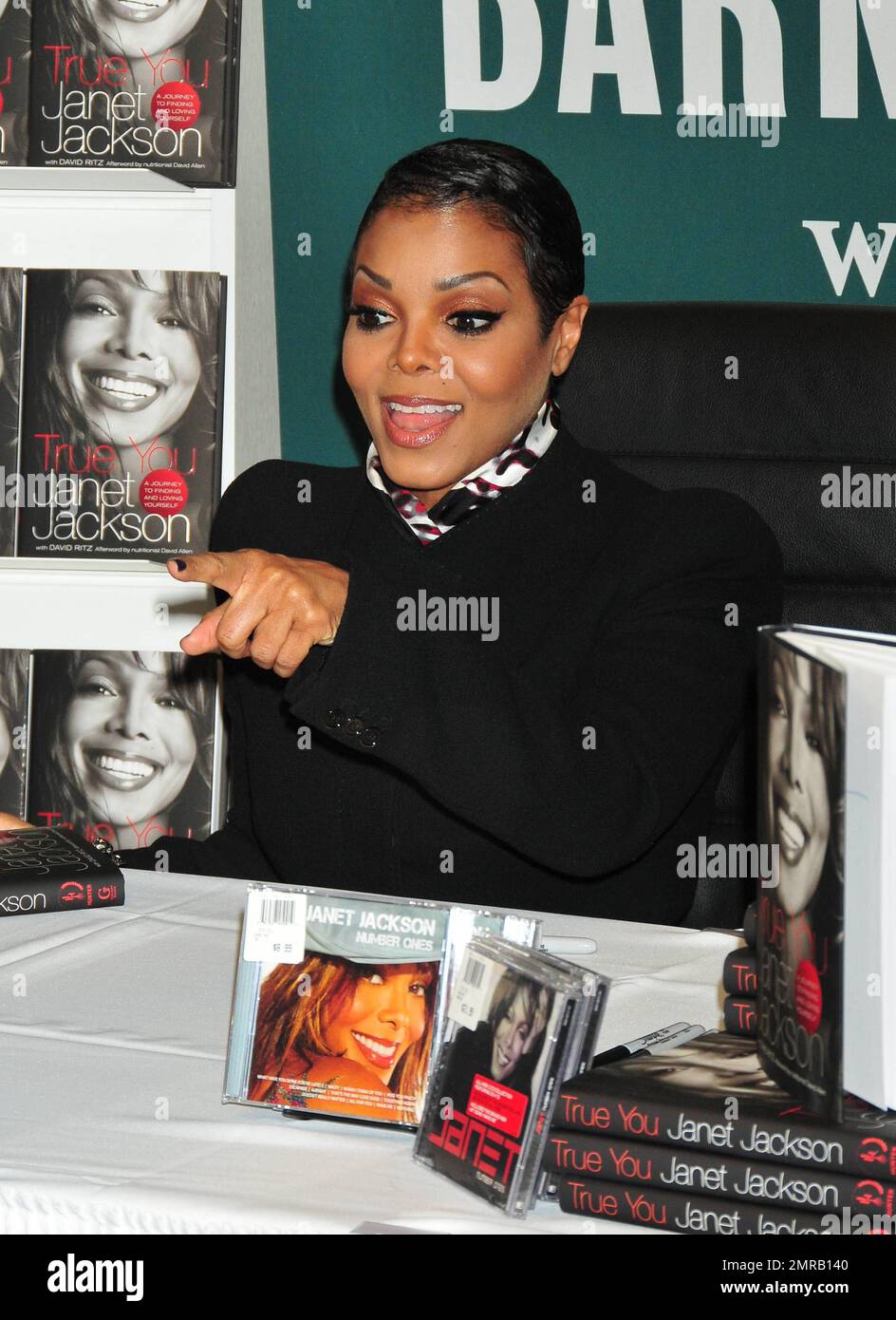 Singer Janet Jackson shows off her short slicked back hair and wears a ...