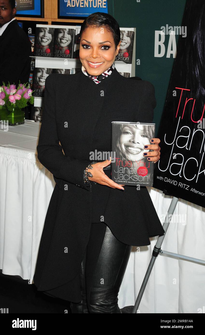 Singer Janet Jackson shows off her short slicked back hair and wears a ...