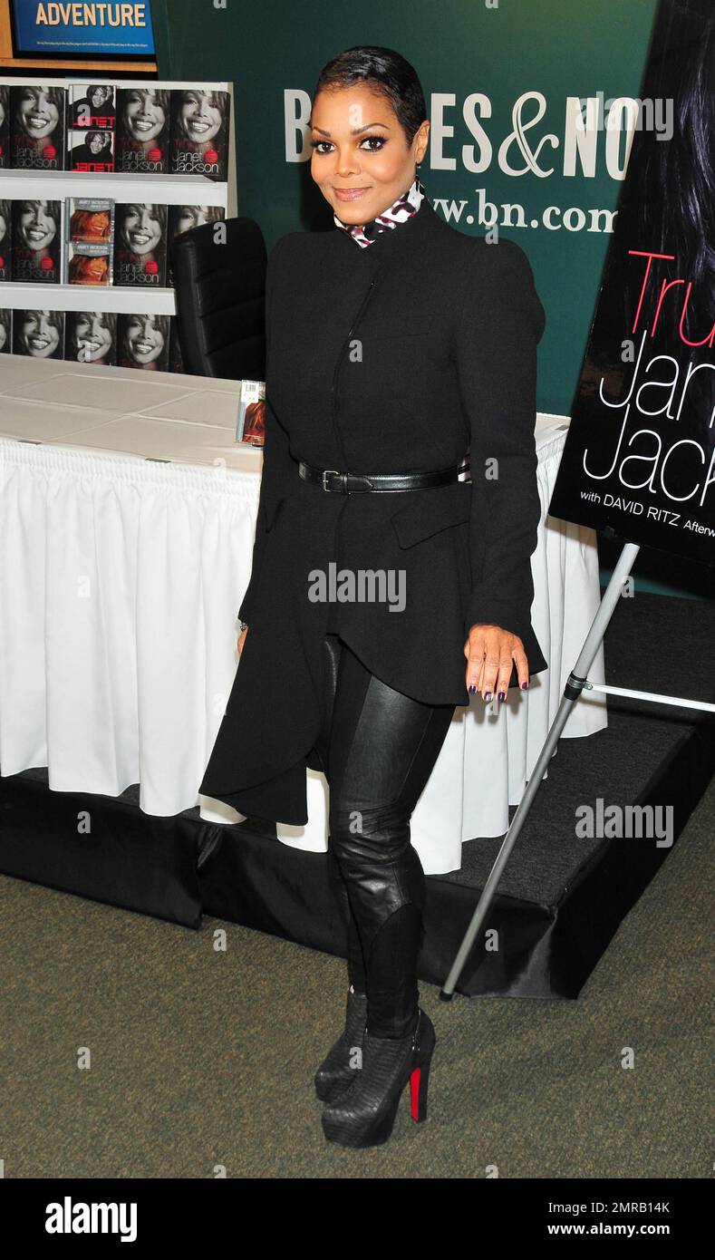 Singer Janet Jackson shows off her short slicked back hair and wears a ...