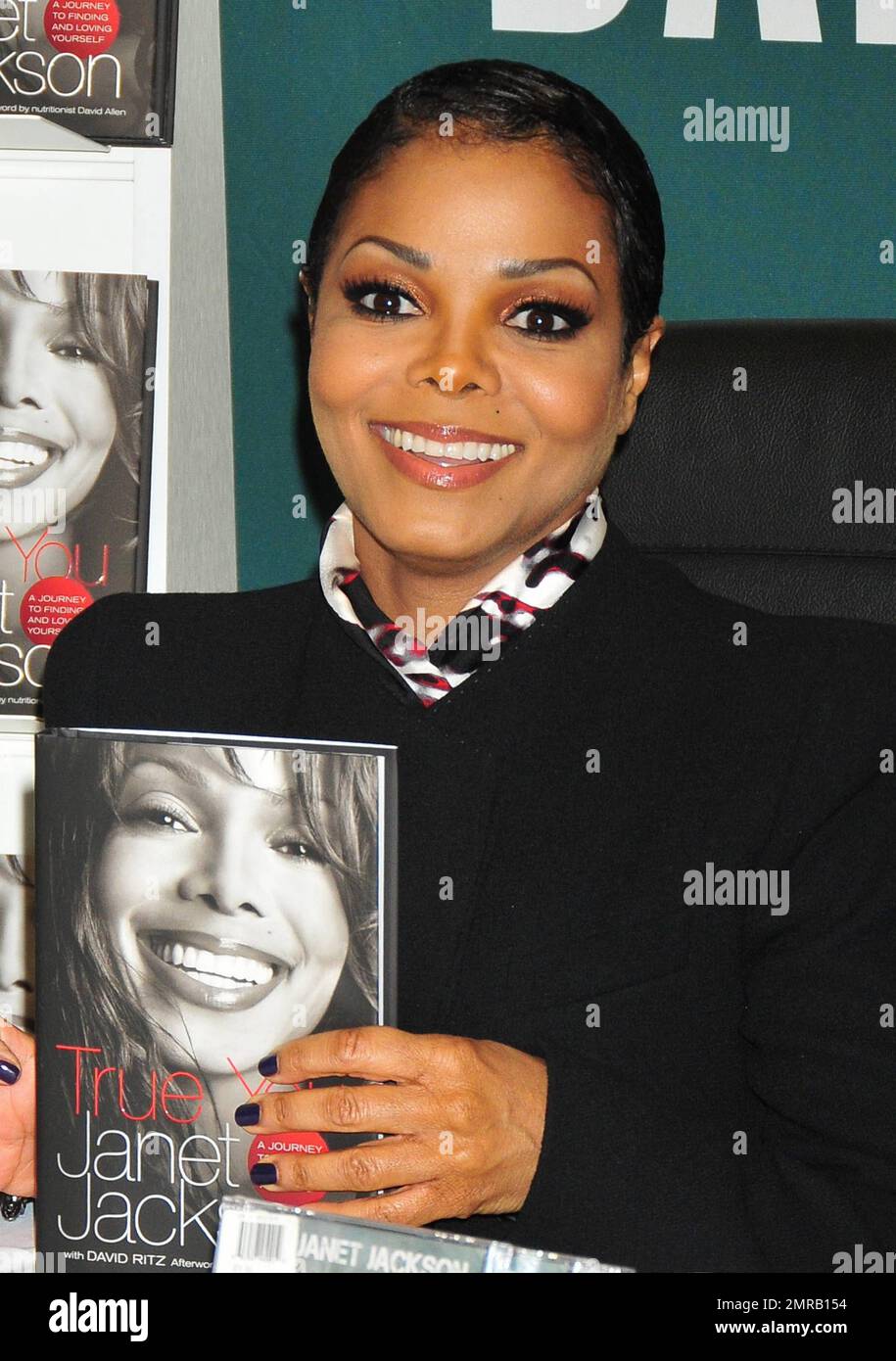 Singer Janet Jackson shows off her short slicked back hair and wears a ...