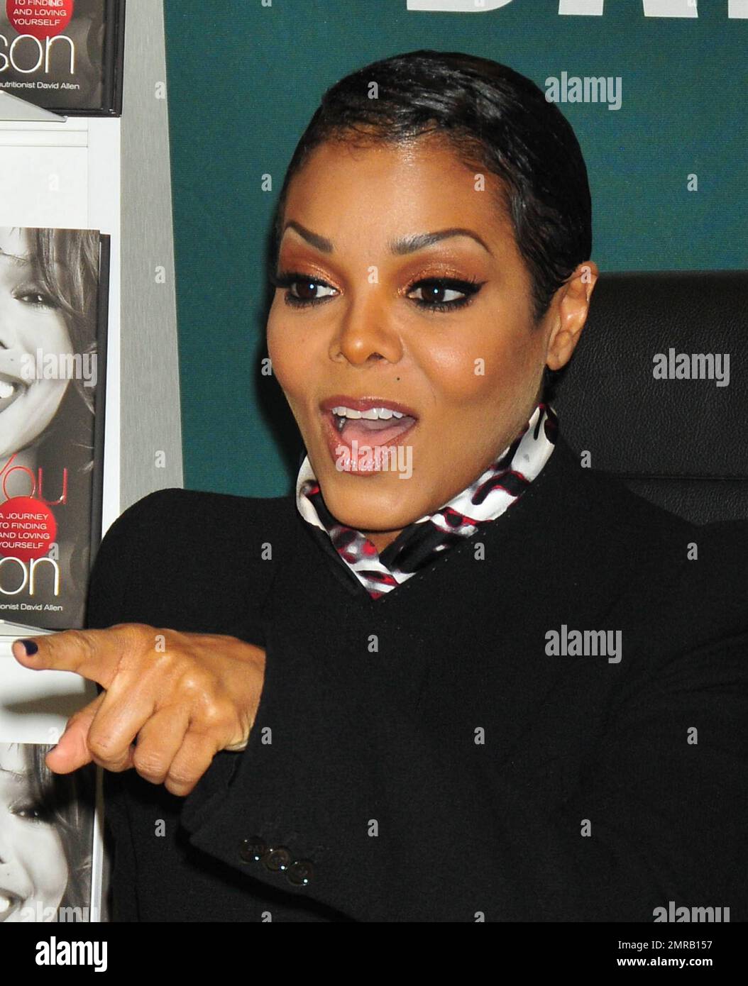 Singer Janet Jackson shows off her short slicked back hair and wears a ...