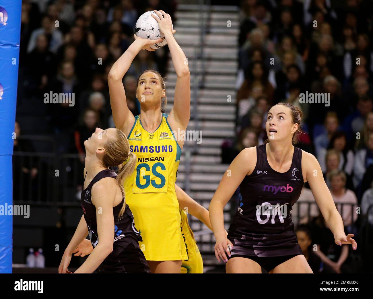 Australia's Caitlin Bassett, centre, takes a shot as New Zealand's ...