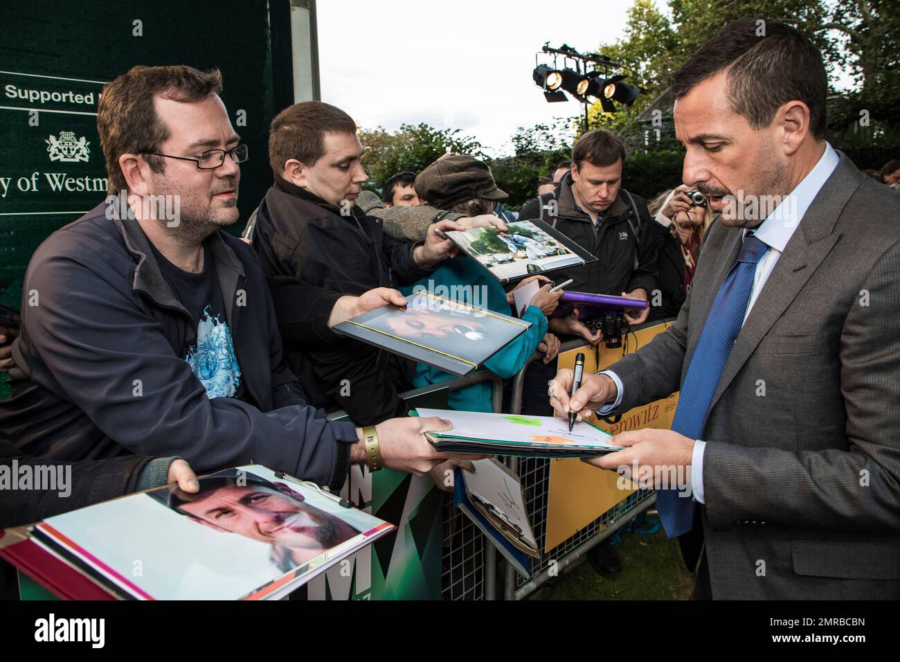 Actor Adam Sandler signs autographs upon arrival at the premiere of the ...