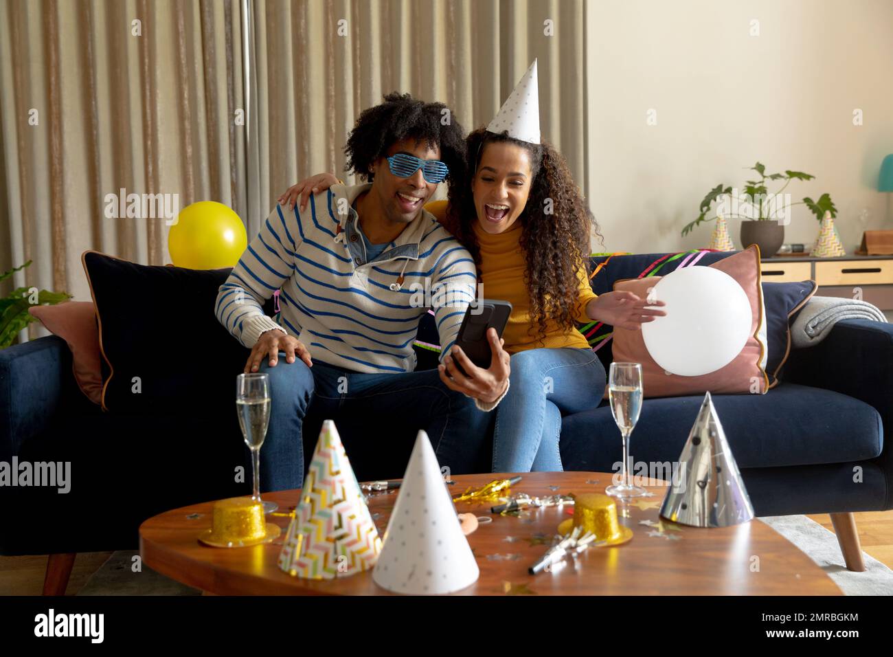 Happy biracial couple having party at home, making celebration video ...