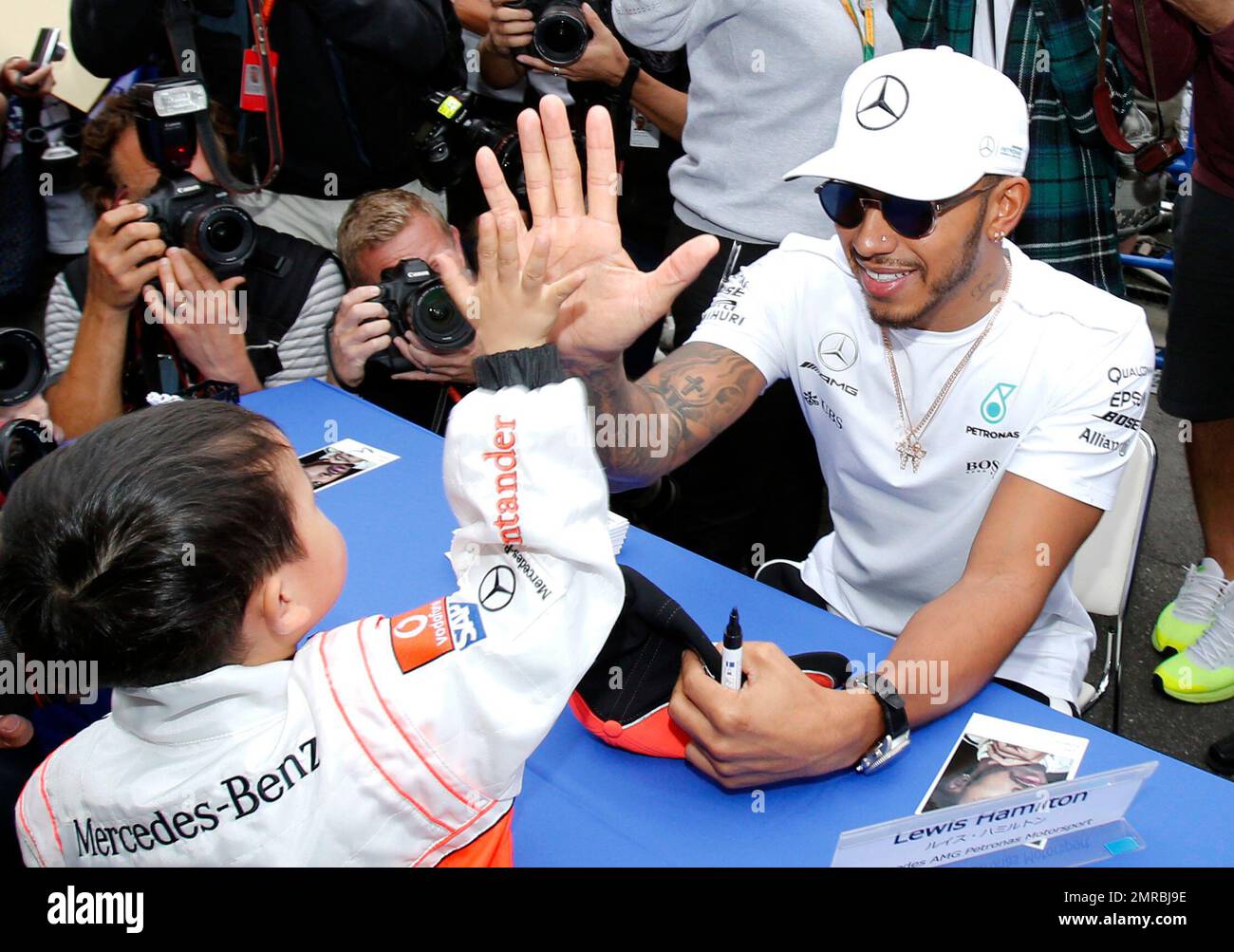 Mercedes driver Lewis Hamilton of Britain gets a high-five from a boy ...