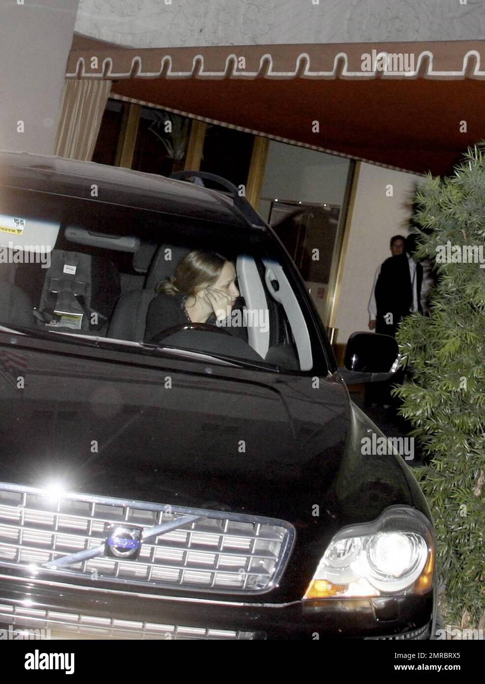 Toby Maguire's wife Jennifer Meyer drives while Toby ducks down to hide ...