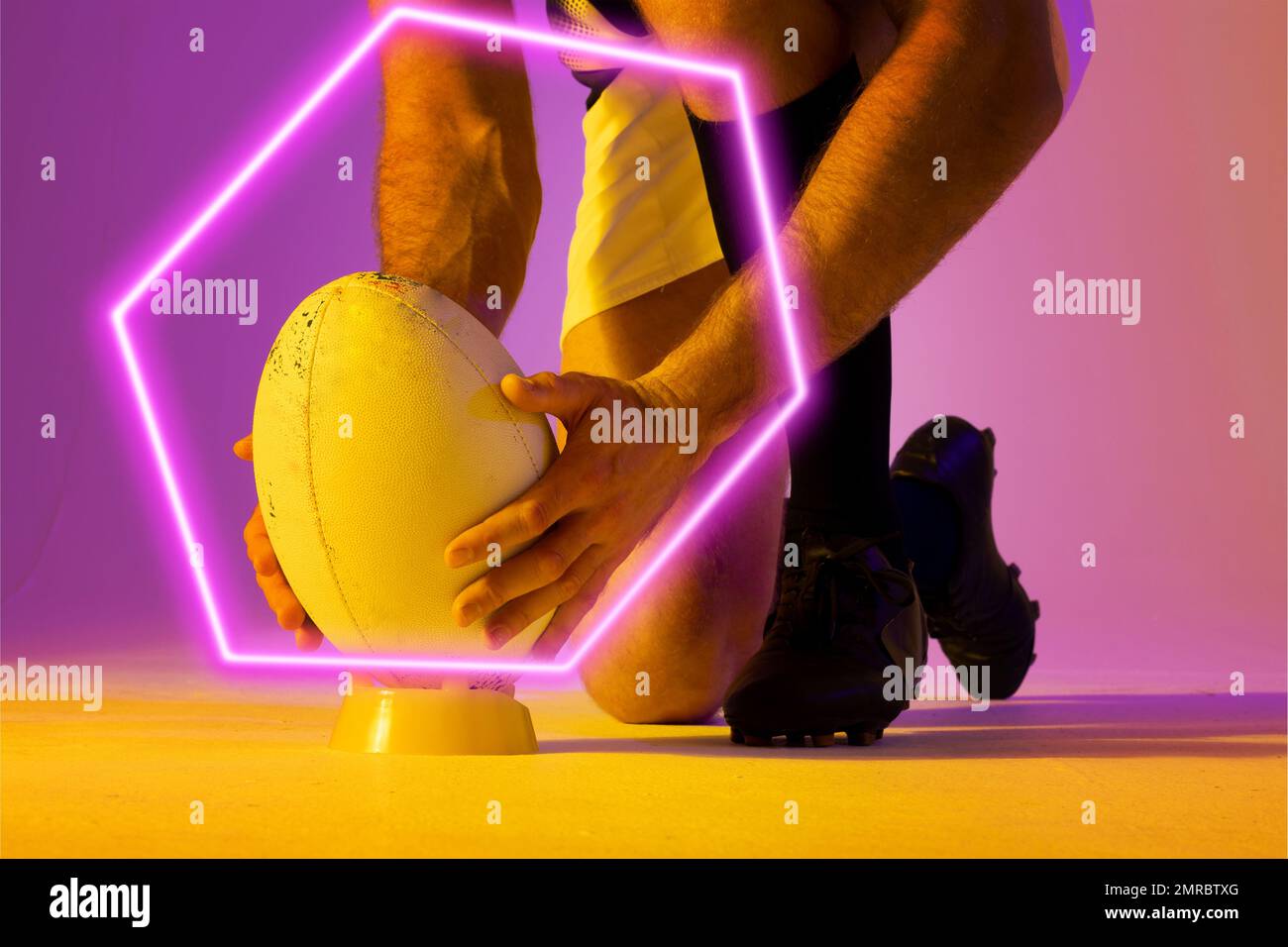 Illuminated hexagon over low section of caucasian male rugby player ...