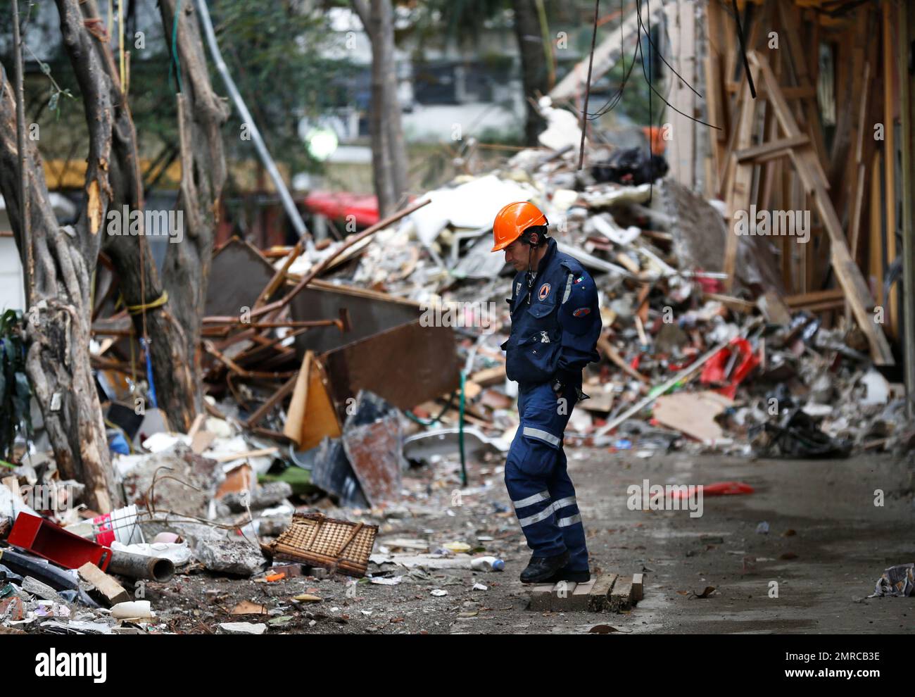 A rescue worker walk amid the rubble of a collapsed building on Tlalpan ...