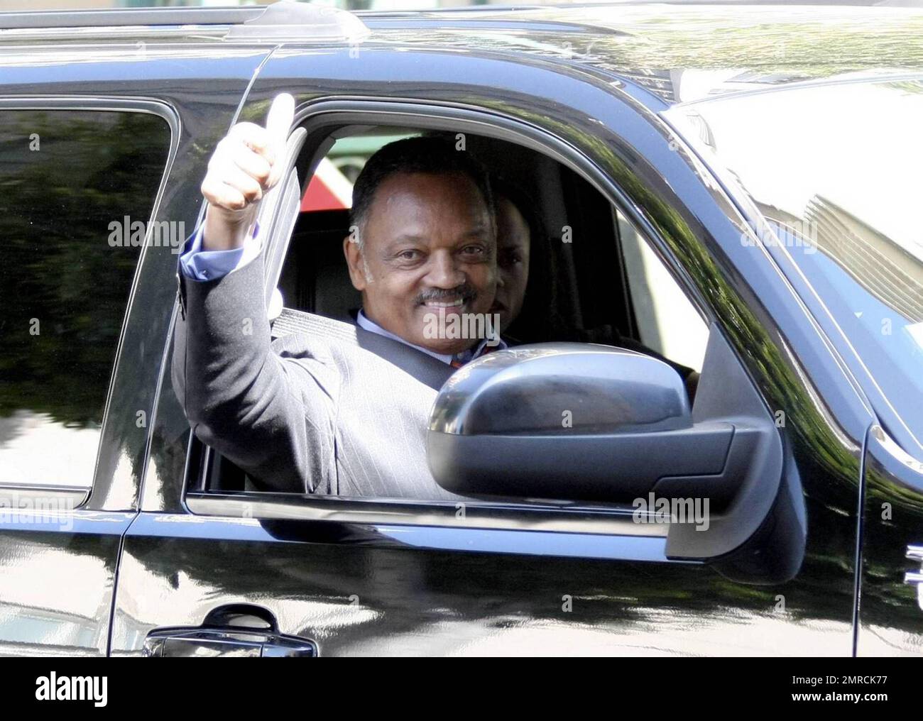 Jesse Jackson is all smiles and flashes thumbs up to photographers and ...