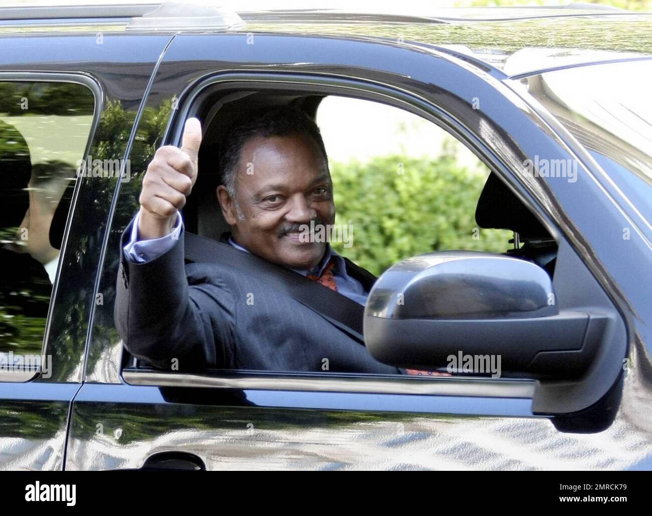 Jesse Jackson is all smiles and flashes thumbs up to photographers and ...