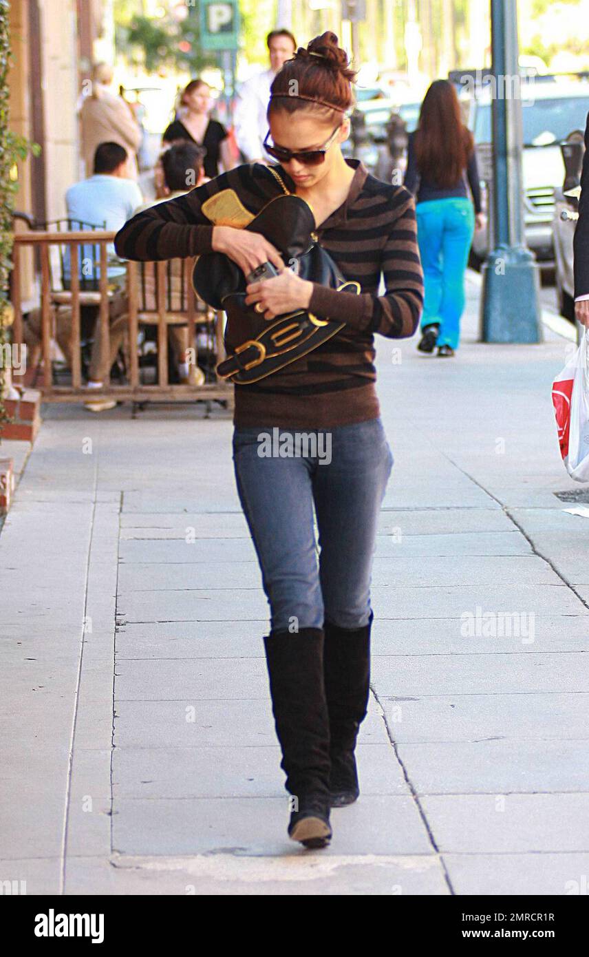 Actress Jessica Alba checks messages on her cellphone while strolling ...