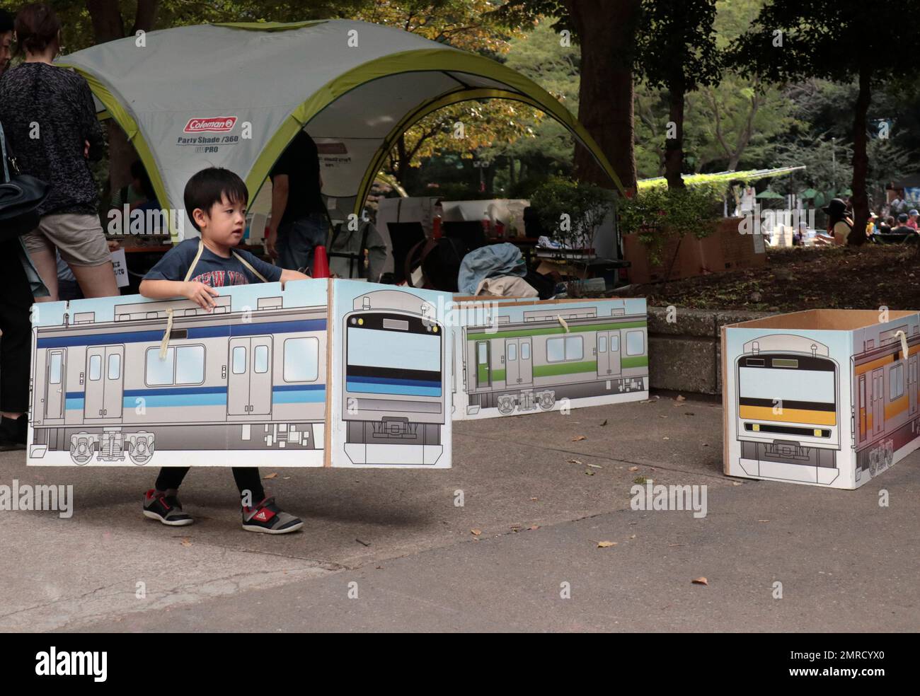 A boy plays with a cardboard box at a park in Tokyo, Sunday, Oct. 1 ...