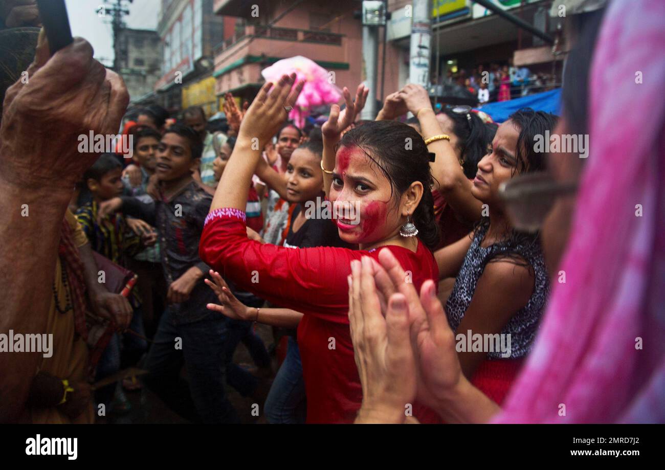 Indian Hindu devotees dance in a procession accompanying an idol of ...